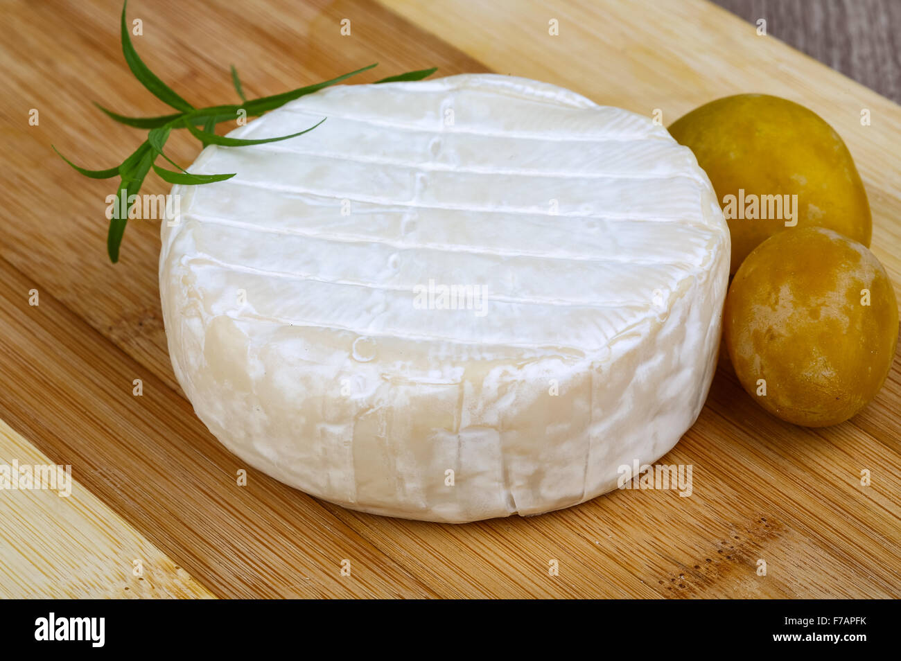 Round Brie cheese with yellow plums and estragon Stock Photo - Alamy