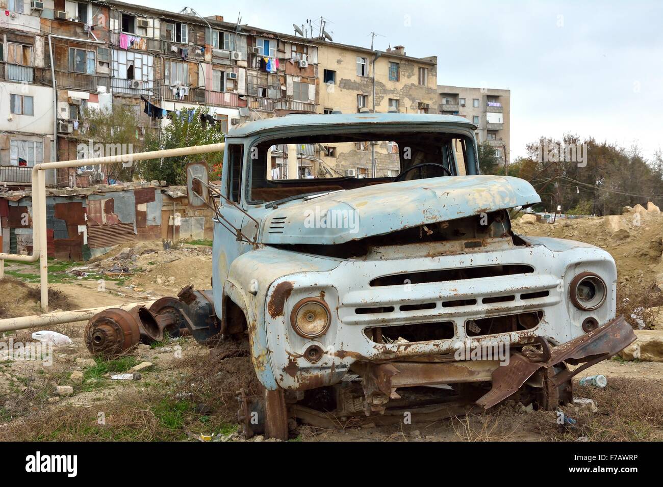 Rusting abandoned van in Baku, capital of Azerbaijan, in front of poor ...
