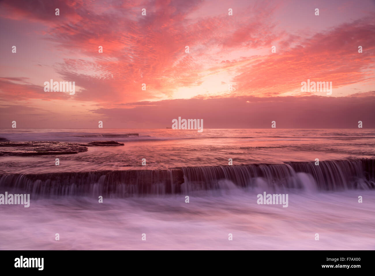 Water flowing over the rock shelf at sunrise Stock Photo - Alamy