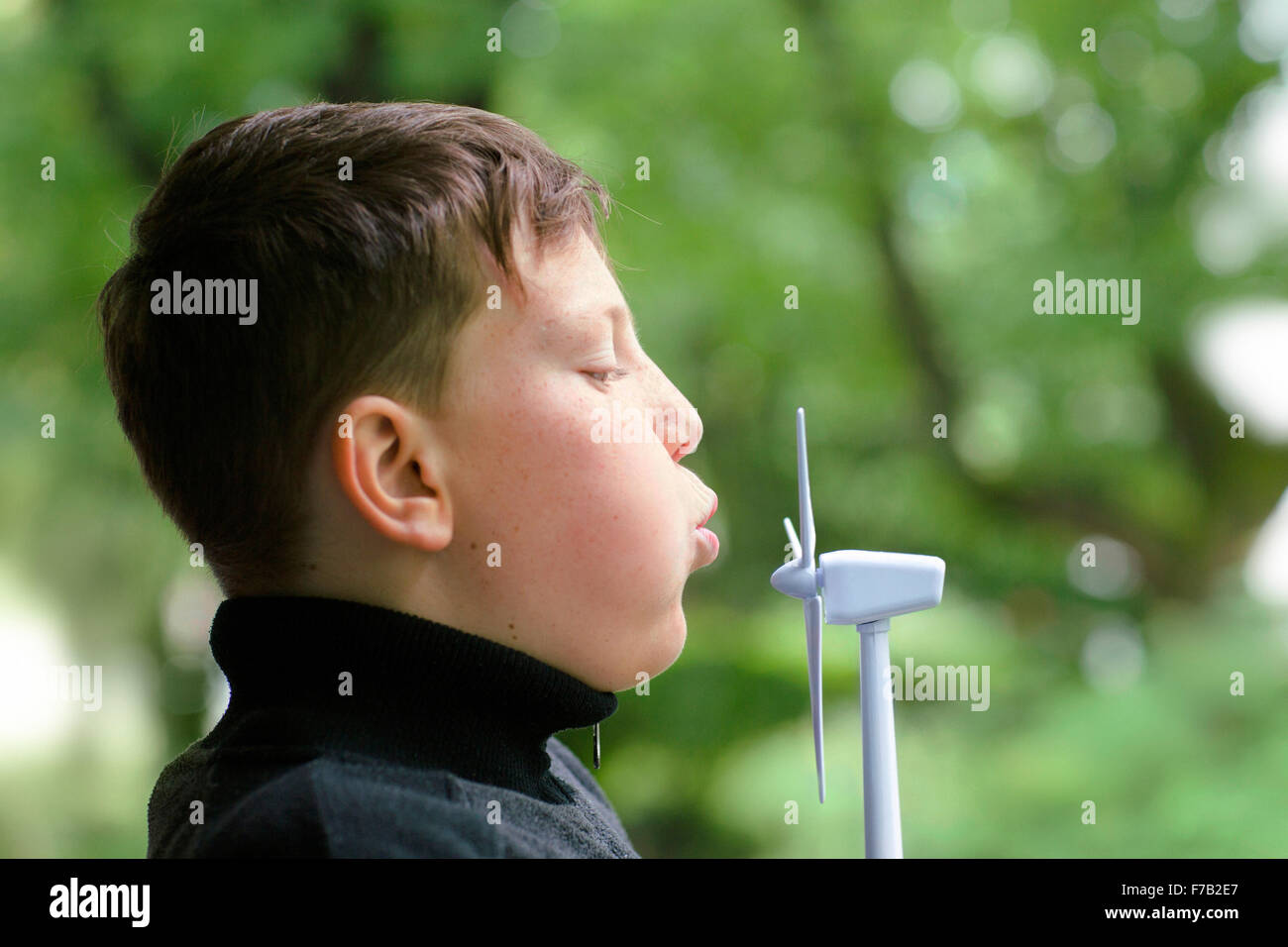 MODEL RELEASED. Boy blowing a miniature wind turbine Stock Photo - Alamy