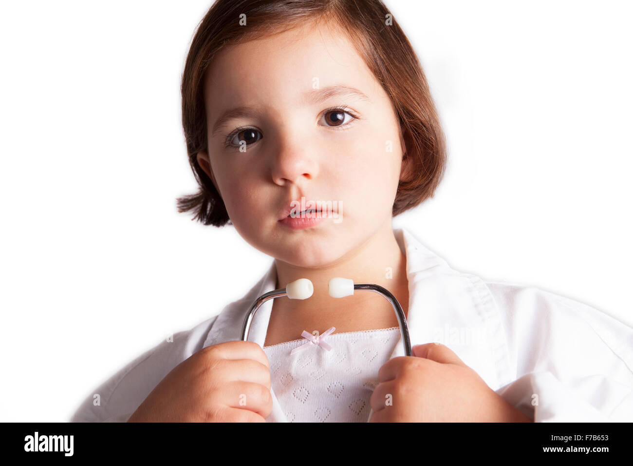 Little girl playing with a stethoscope. Isolated over white background ...
