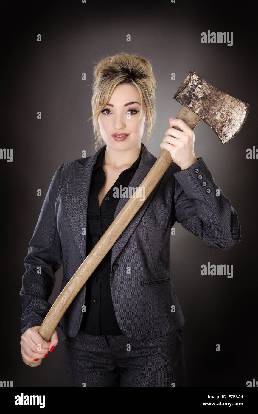 business woman holding a large axe shot in the studio on a gray ...