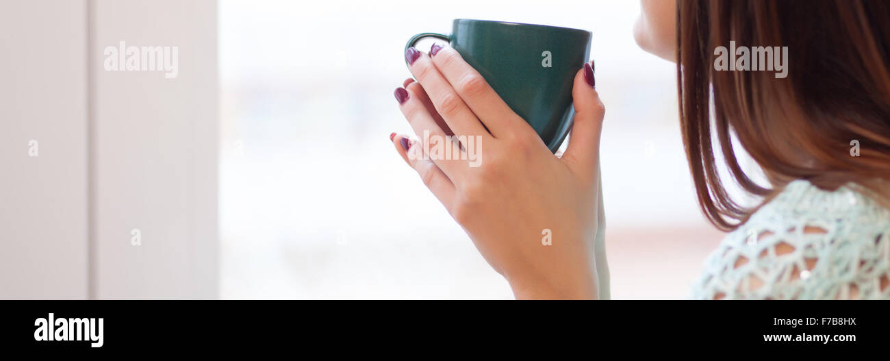 woman in a window with a cup of tea on her hands Stock Photo - Alamy