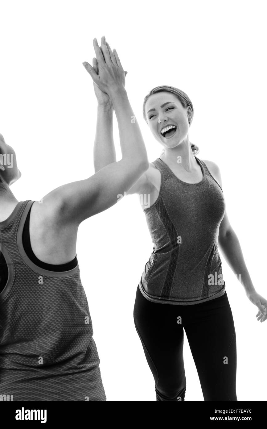 two fitness woman high fiving each other Stock Photo - Alamy