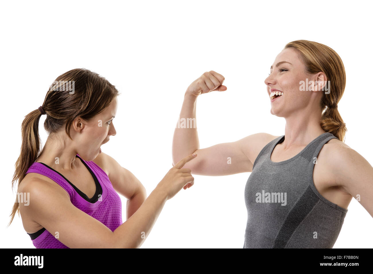 two fitness woman one showing the other how strong she is by flexing ...