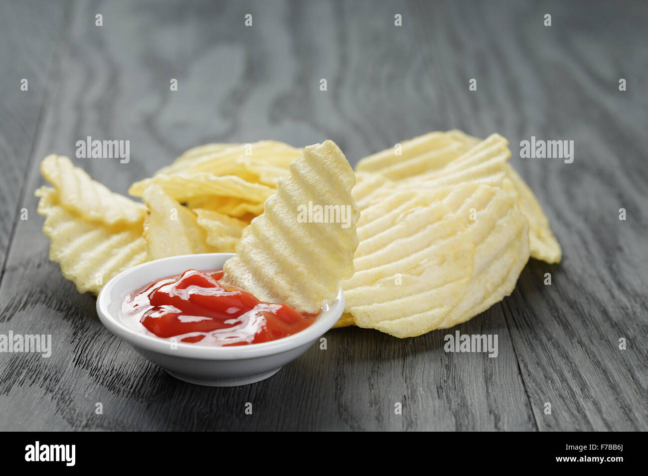 salted potato ships with sauce on old wooden table Stock Photo - Alamy