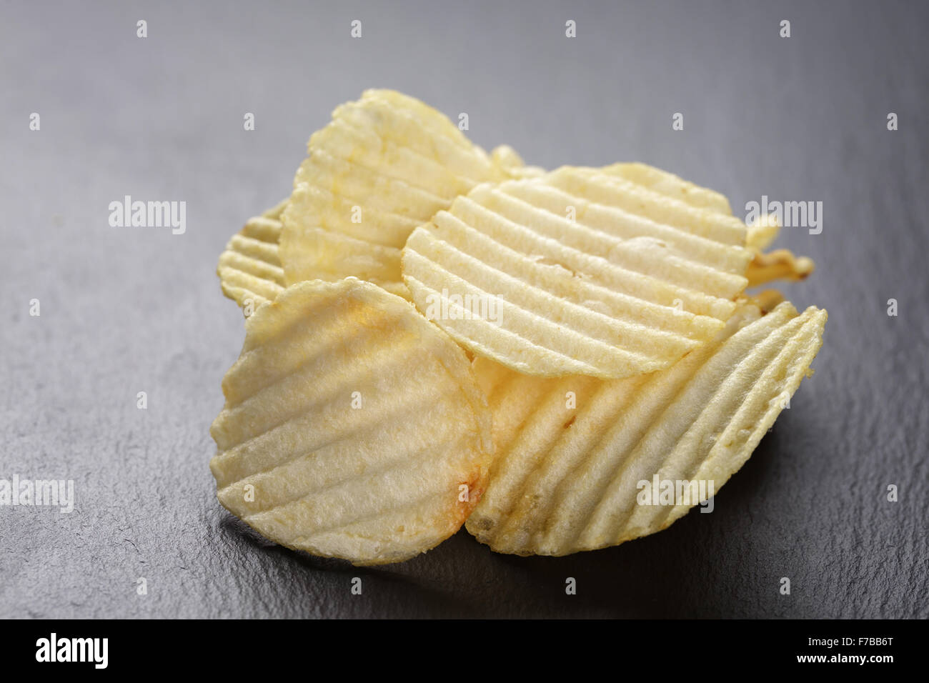 salted potato ships on old slate board Stock Photo - Alamy
