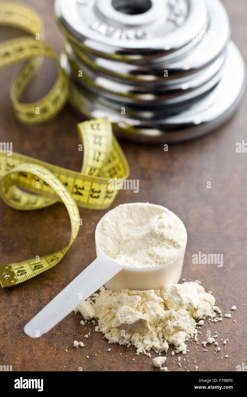 the whey protein in scoop and dumbbell Stock Photo - Alamy