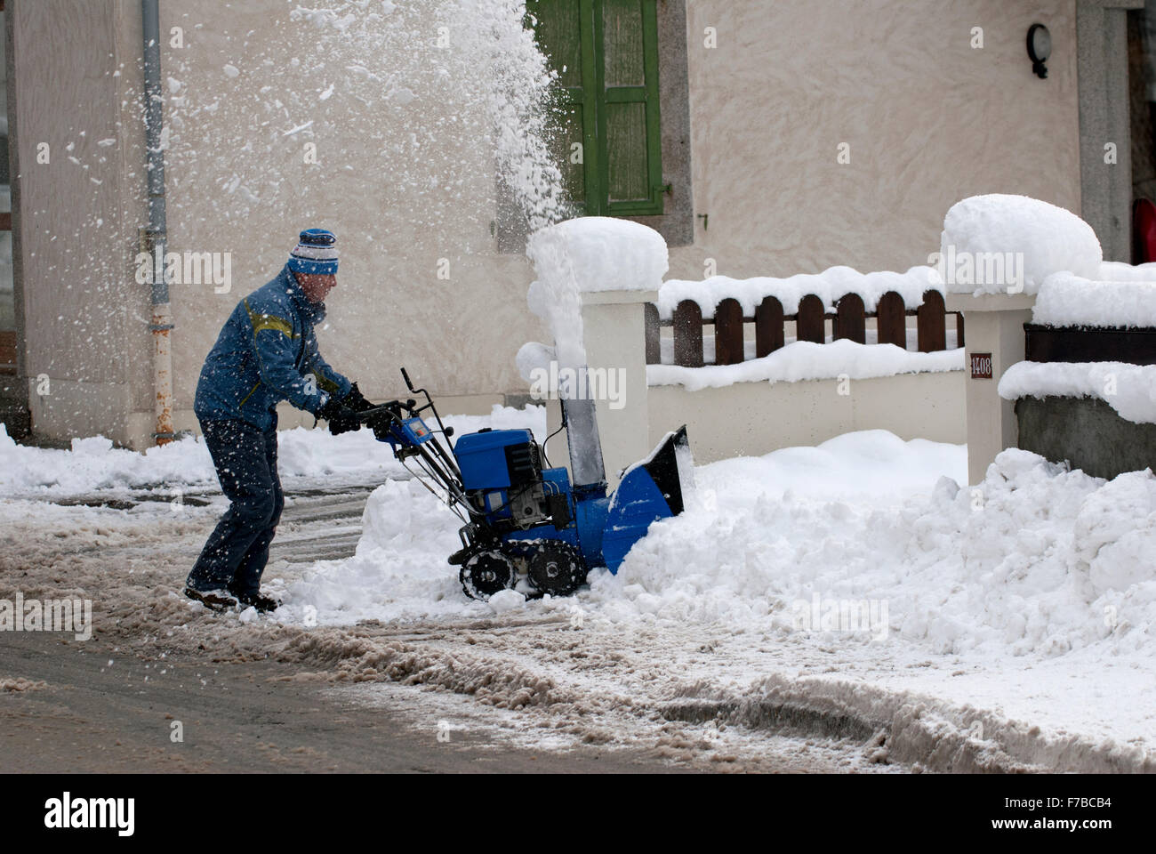 Man with snow blower clearing a path into his driveway Stock Photo - Alamy
