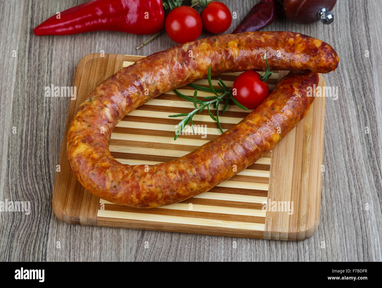 Sausage ring with rosemary and pepper on the wood background Stock ...