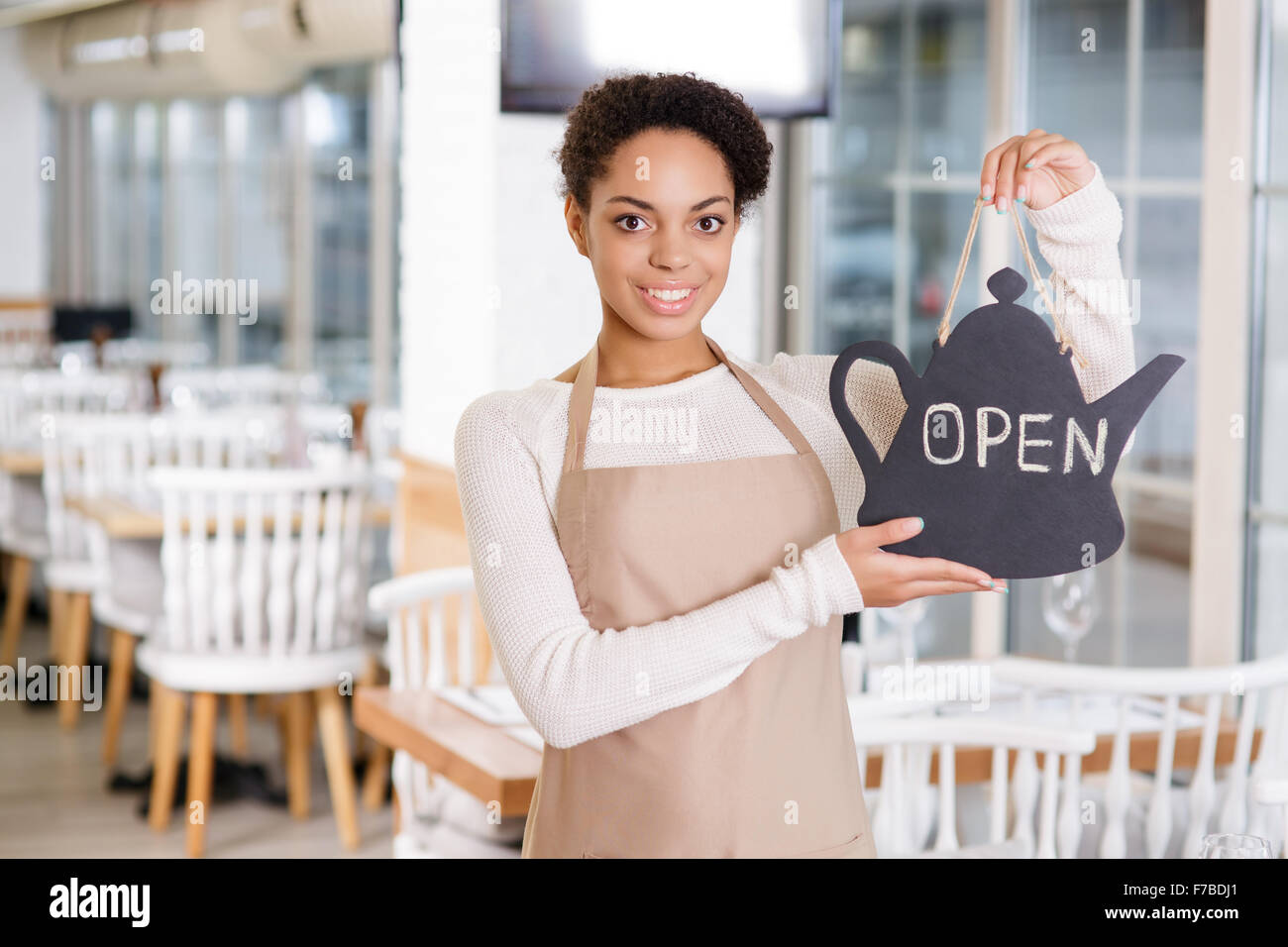 Smiling waitress holding an opening sign Stock Photo - Alamy