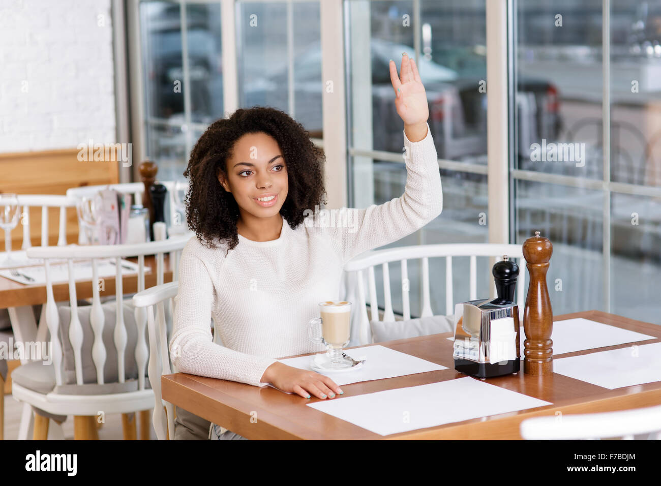 Customer is waving to the waiter Stock Photo - Alamy