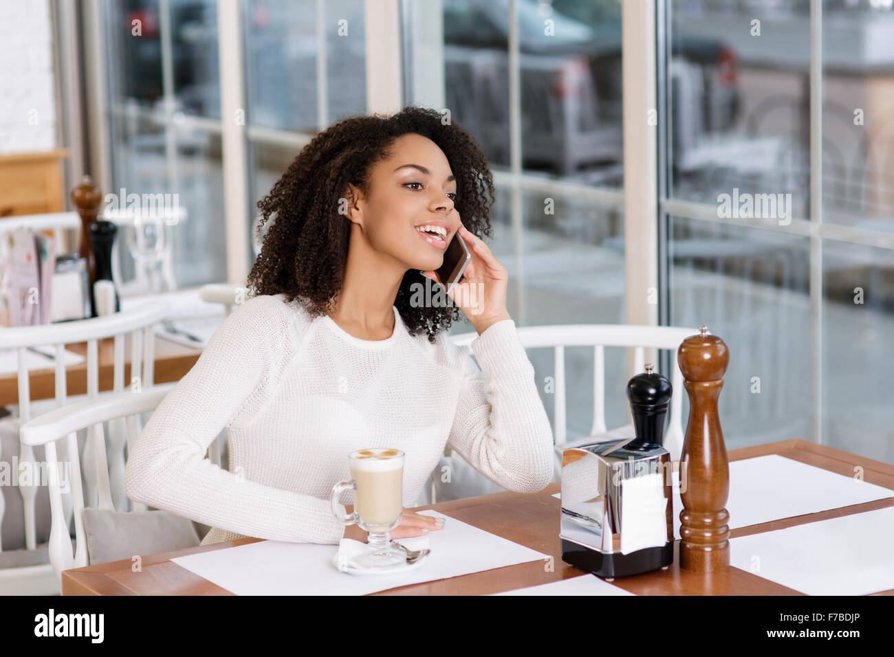 Cheerful young woman making phone call Stock Photo - Alamy