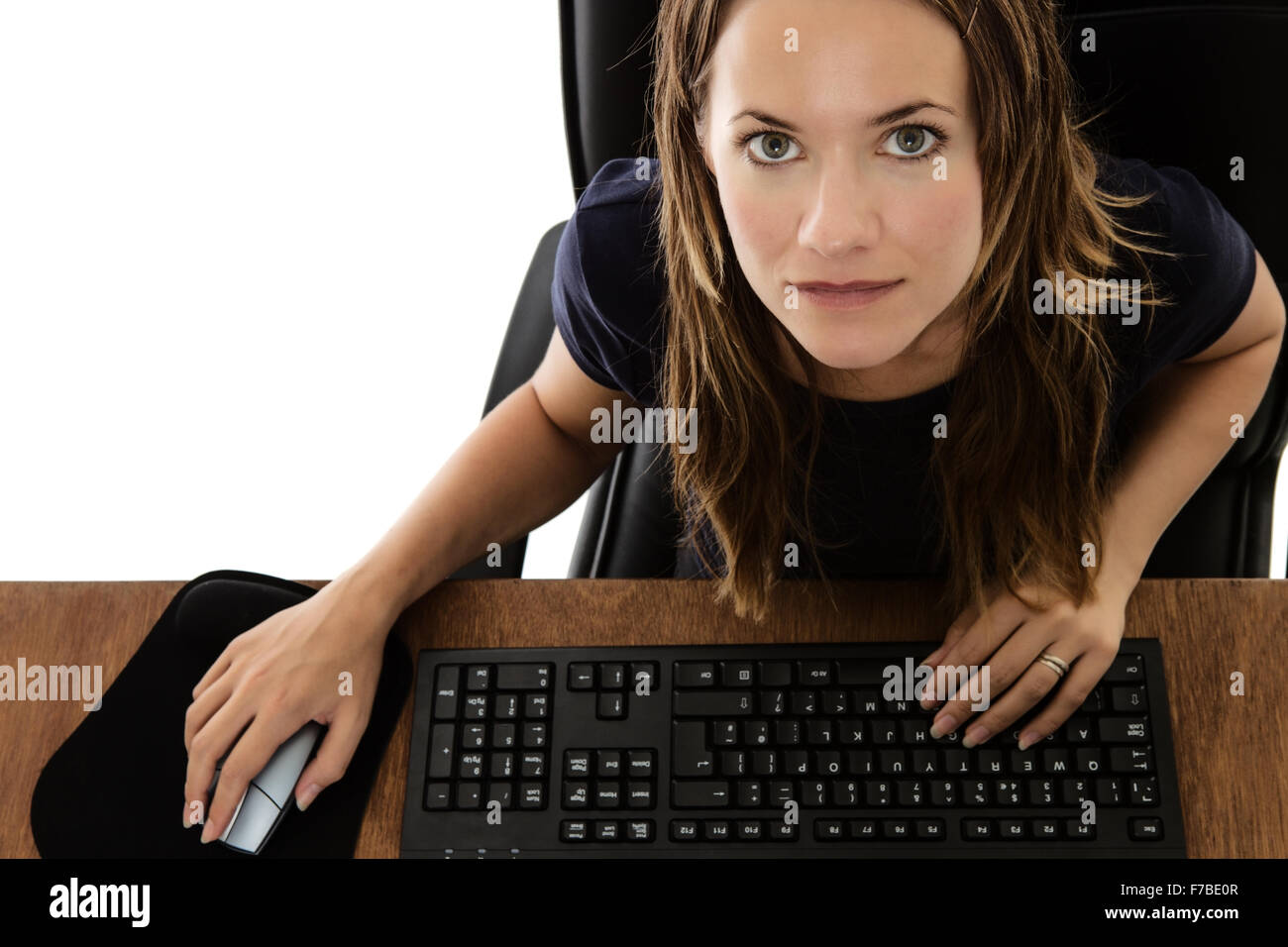shot from above of a businesswoman working at her desk looking up at ...