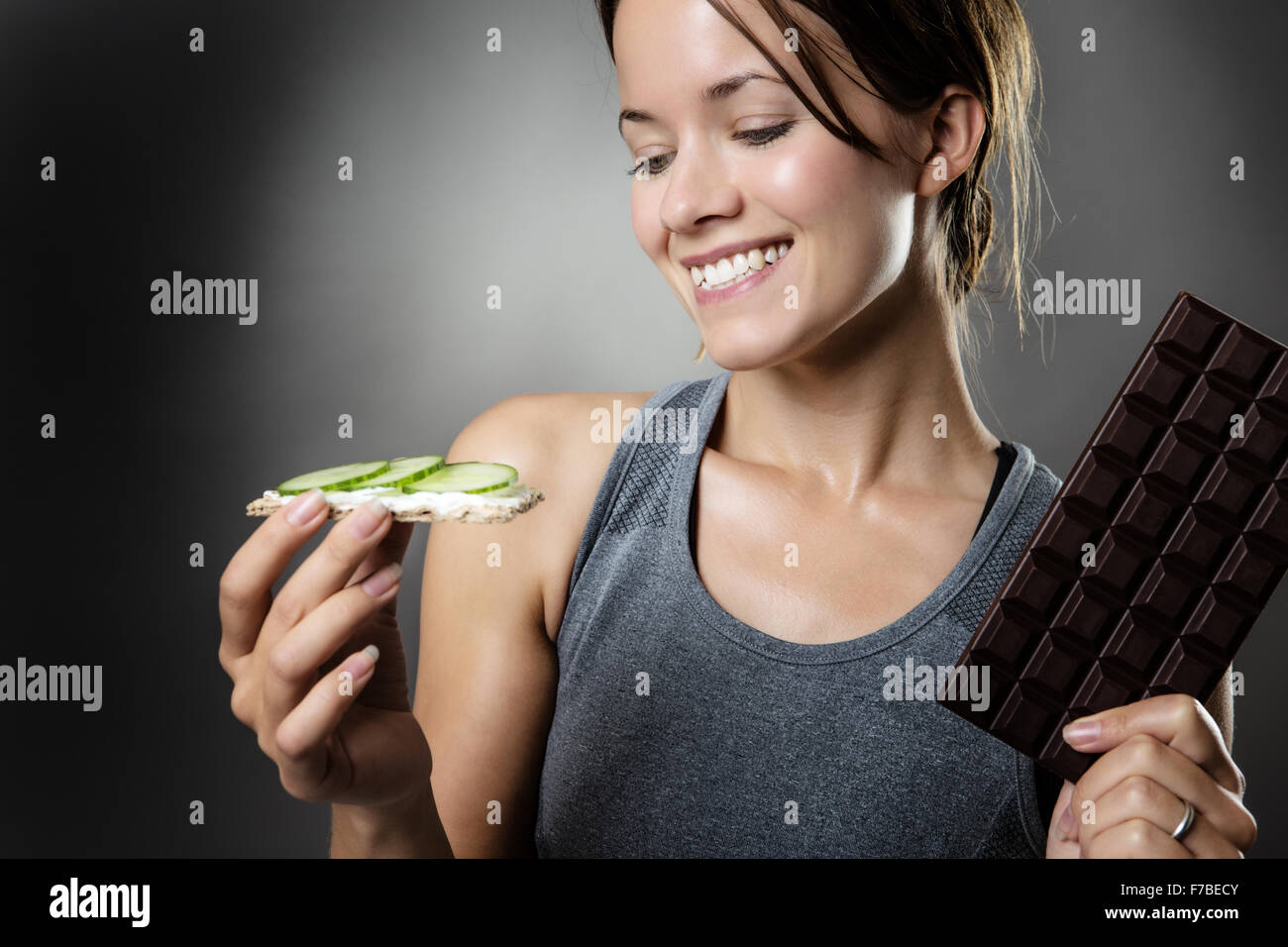 woman holding a crispbread in one hand and a large chocolate bar in the ...