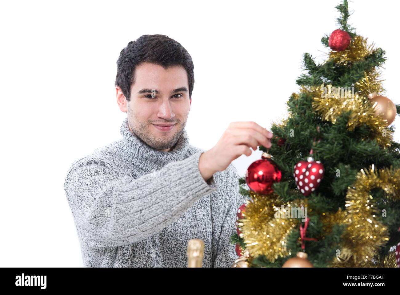 young man decorating Christmas tree, white background Stock Photo - Alamy