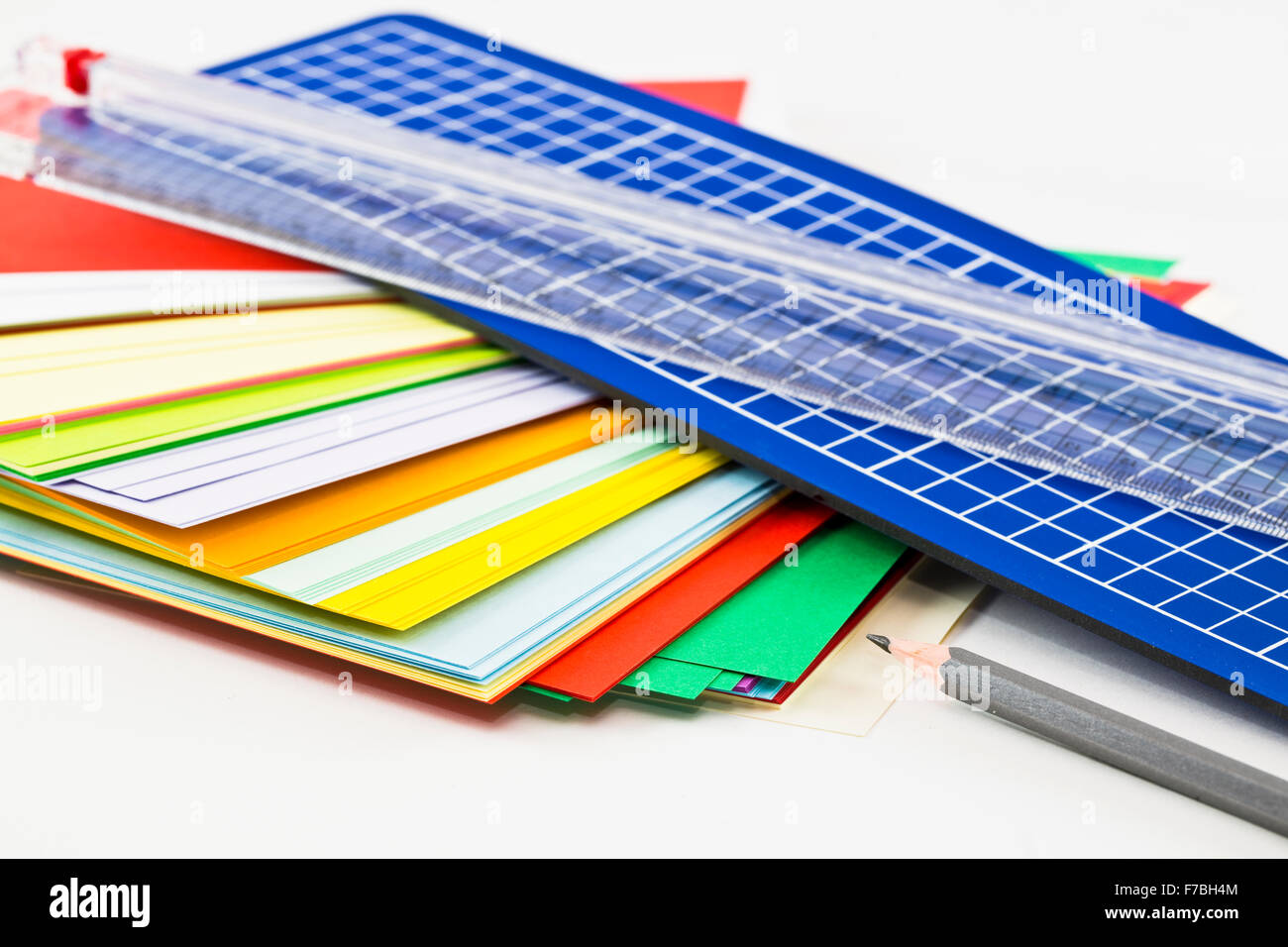 Stack of coloured card with a card cutting guide & a pencil Stock Photo ...