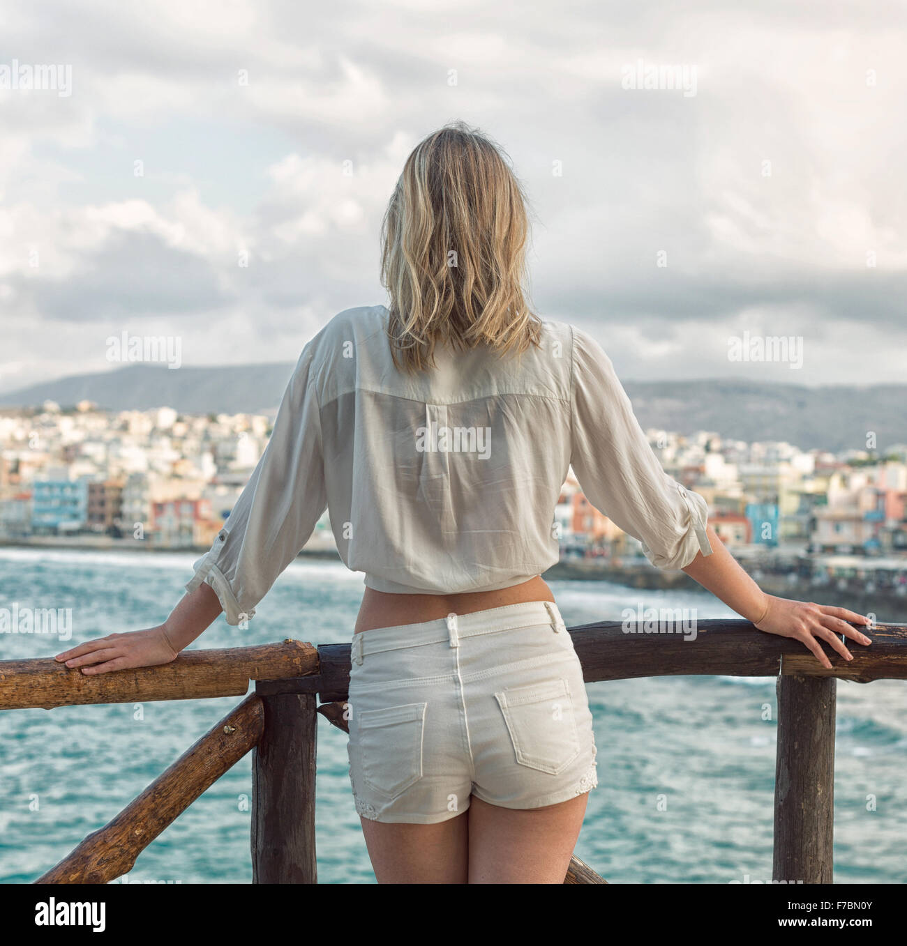 Woman looking at cityscape with bay. From the back. Place for your text ...