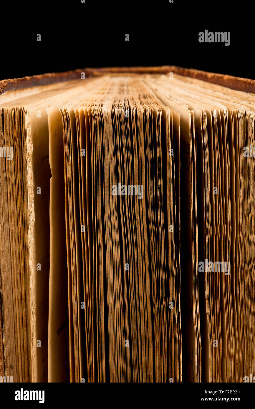 ancient book shot on black background. The book is in bad condition ...