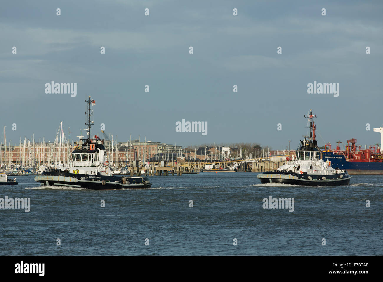 Matching tug boats heading out of Portsmouth harbour. White and black ...