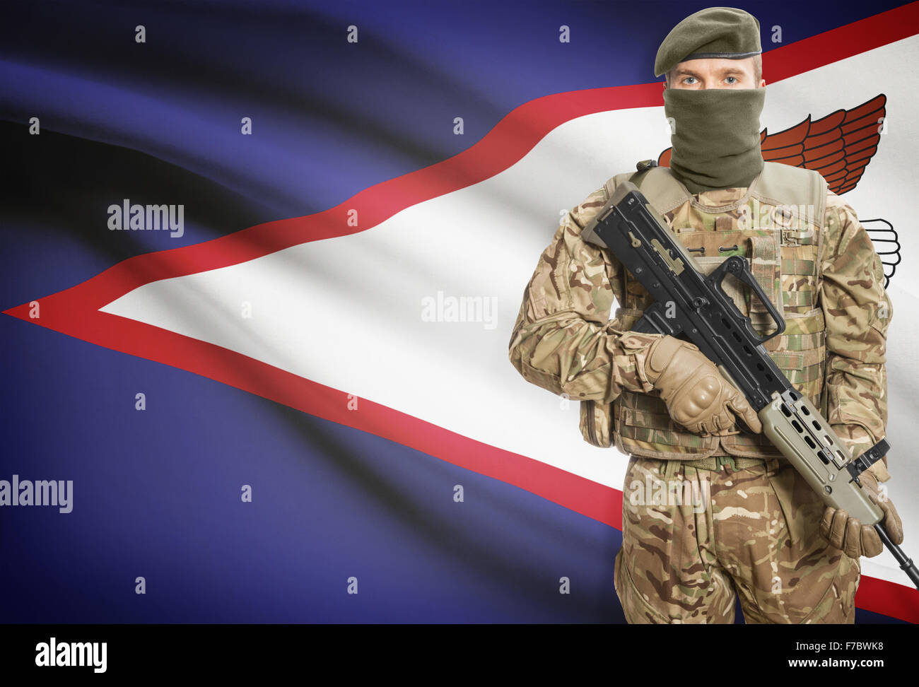 Soldier holding machine gun with national flag on background - American ...