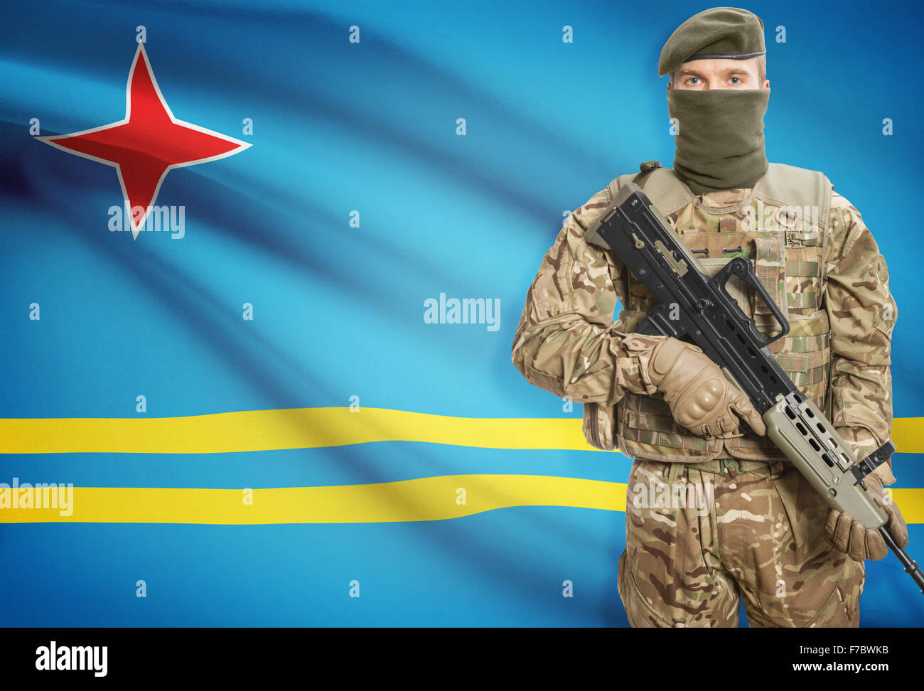 Soldier holding machine gun with national flag on background - Aruba ...