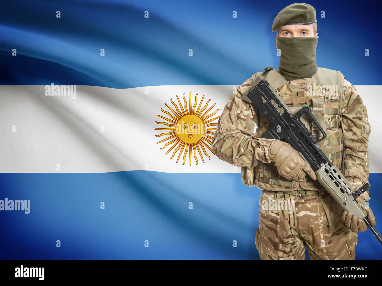 Soldier holding machine gun with national flag on background ...