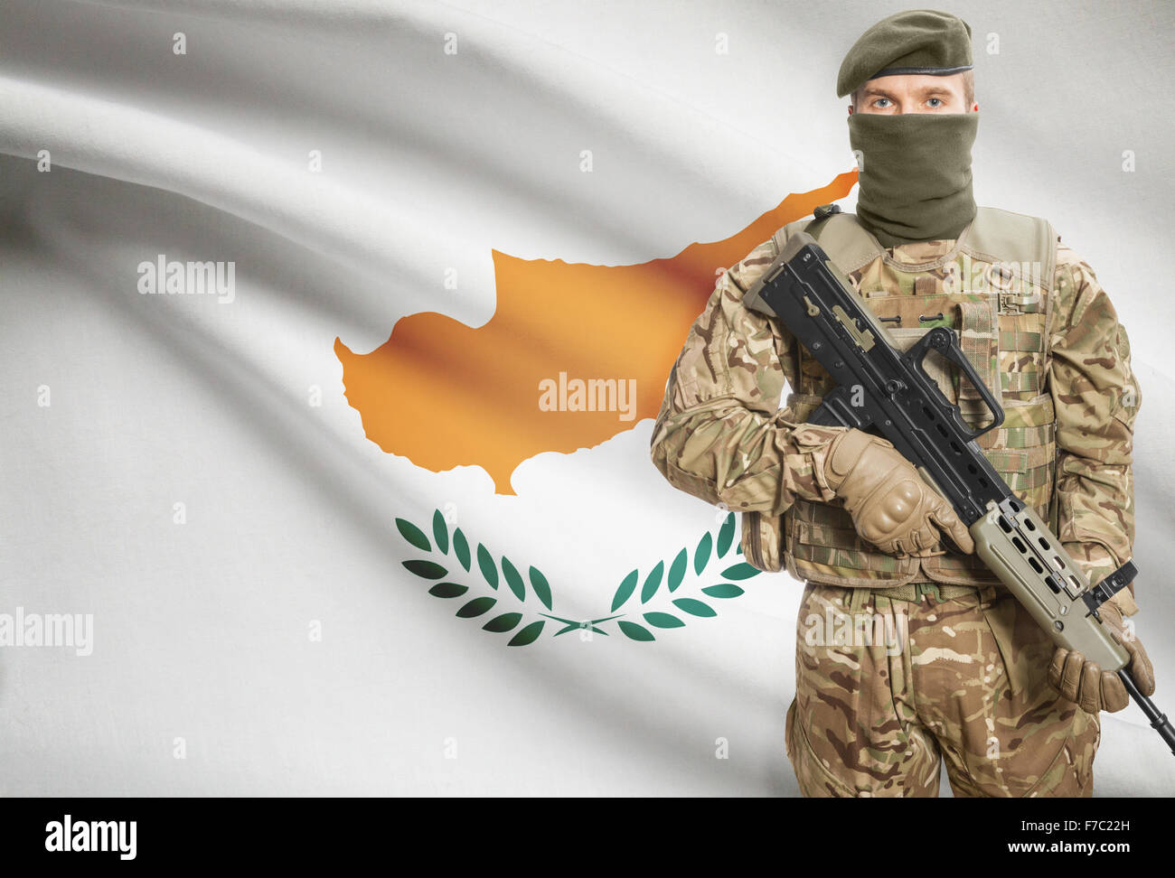 Soldier holding machine gun with national flag on background - Cyprus ...