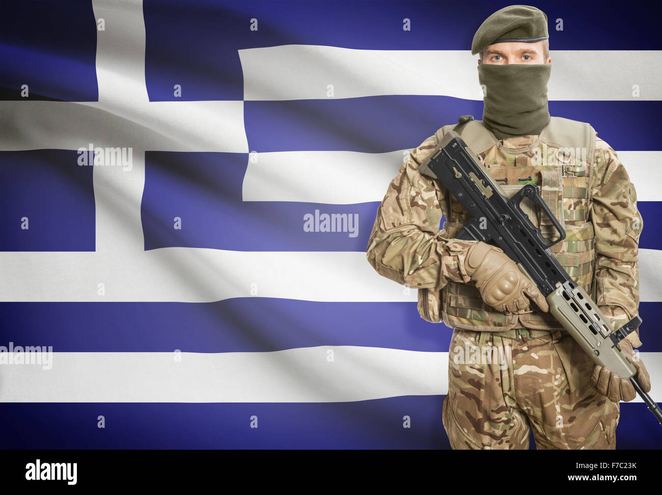 Soldier holding machine gun with national flag on background - Greece ...