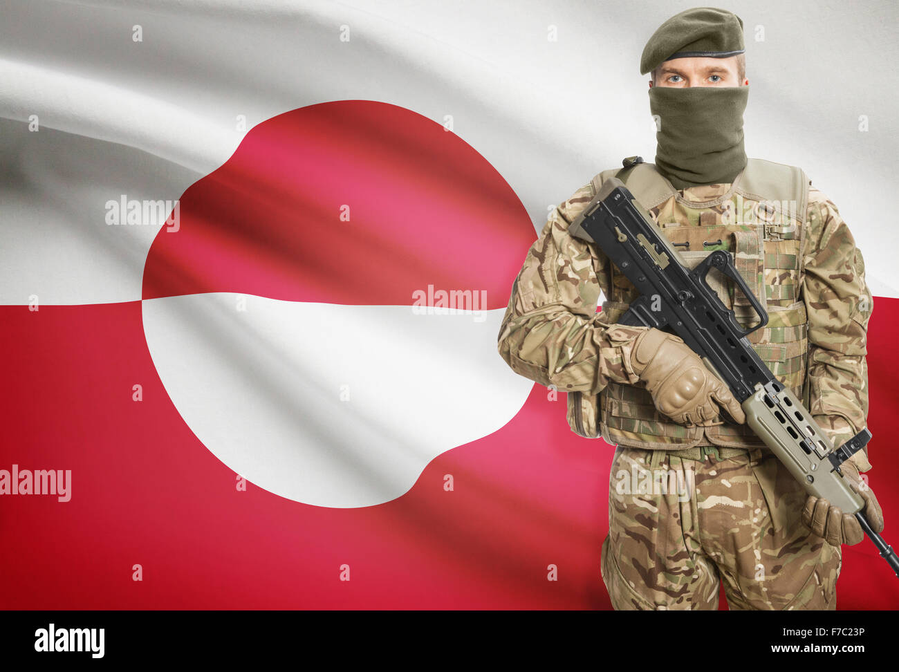 Soldier holding machine gun with national flag on background ...