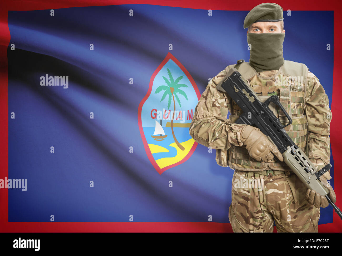 Soldier holding machine gun with national flag on background - Guam ...