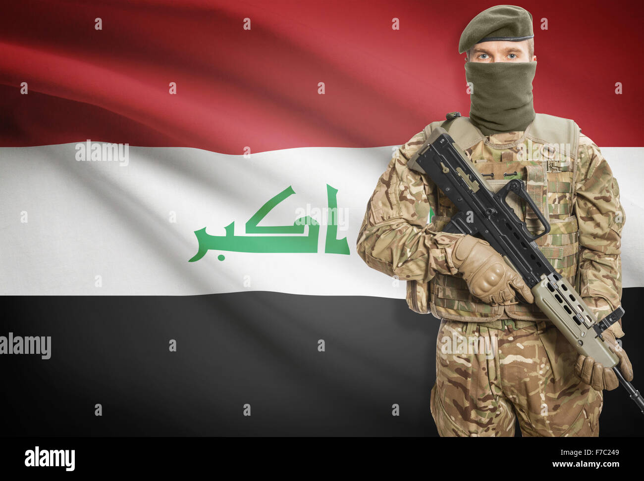 Soldier holding machine gun with national flag on background - Iraq ...