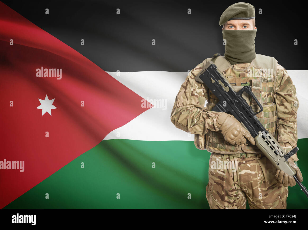 Soldier holding machine gun with national flag on background - Jordan ...