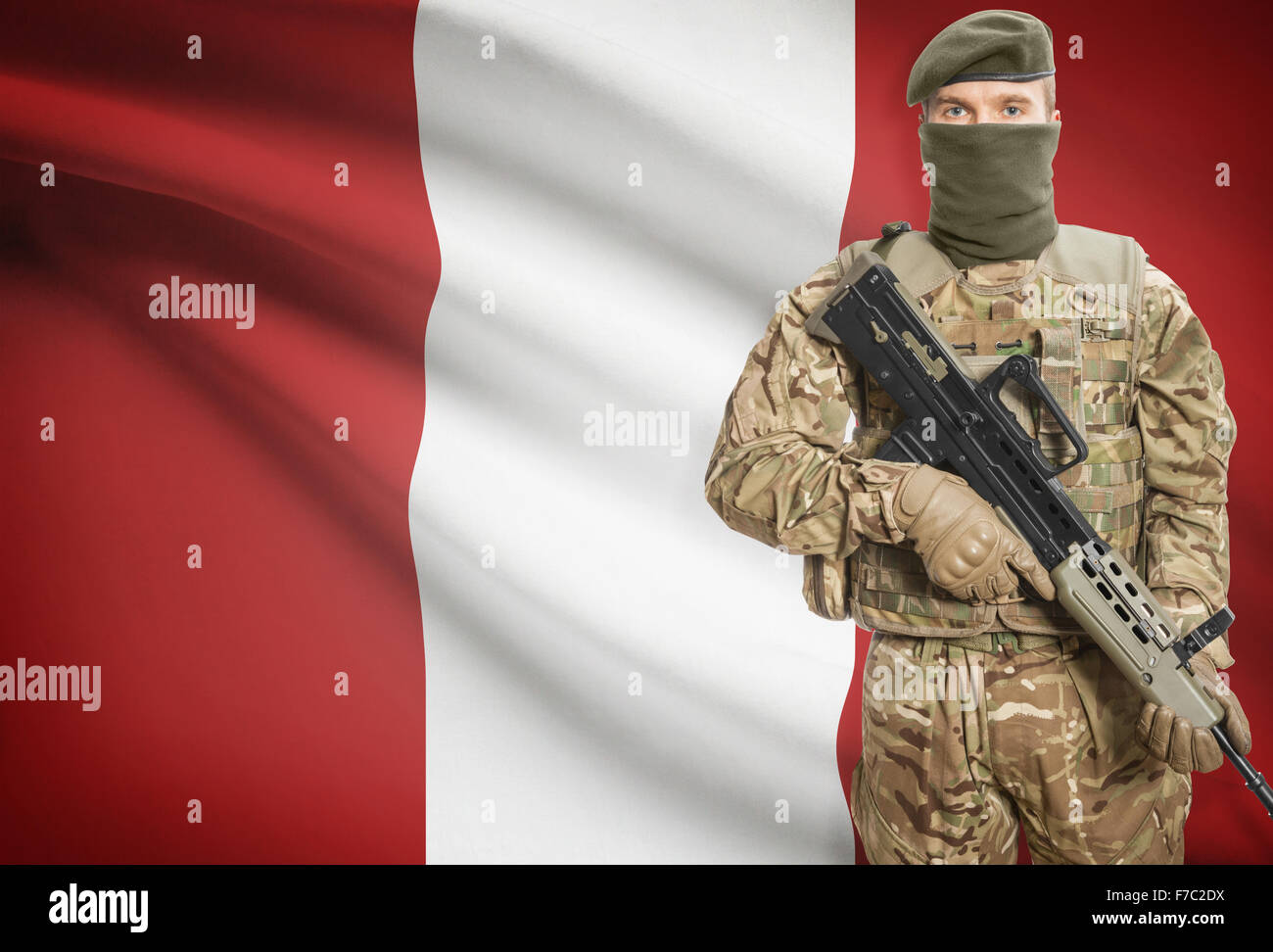 Soldier holding machine gun with national flag on background - Peru ...