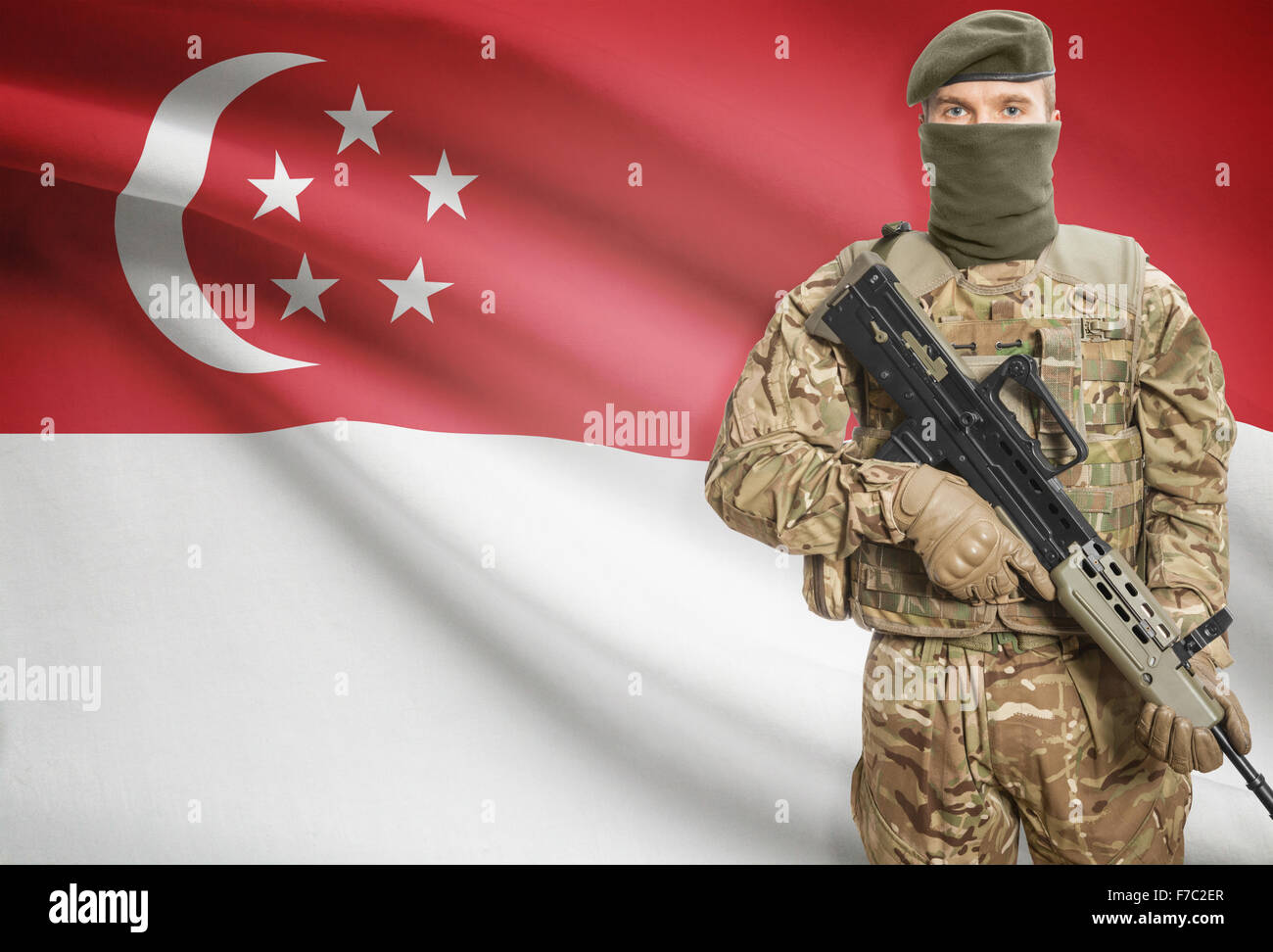 Soldier holding machine gun with national flag on background ...
