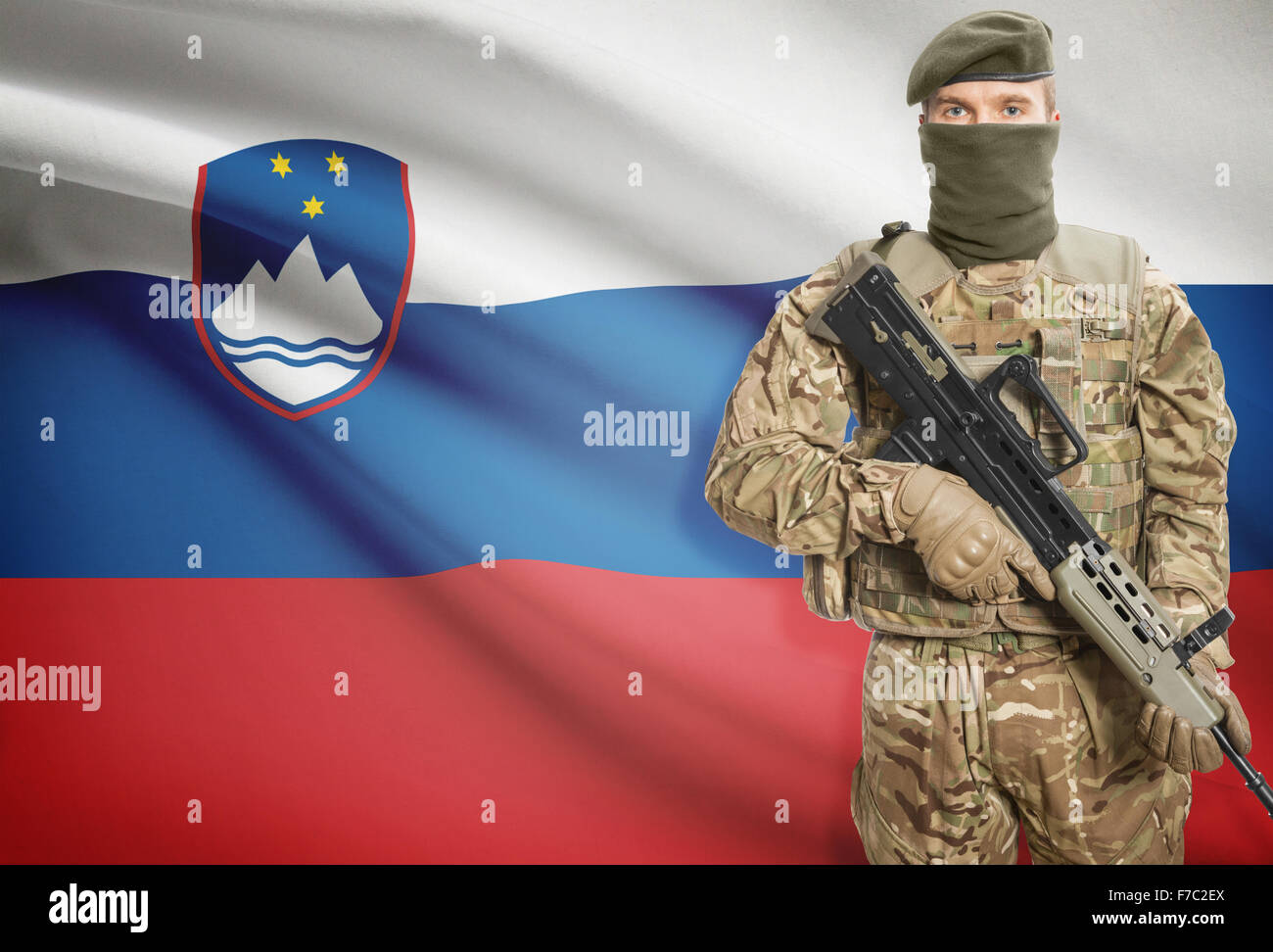 Soldier holding machine gun with national flag on background - Slovenia ...