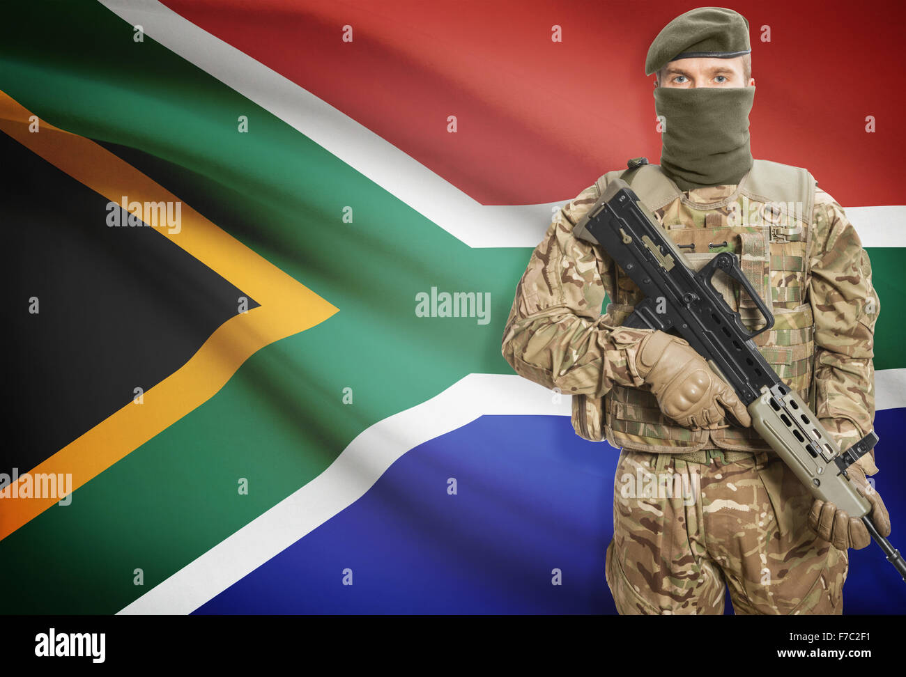 Soldier holding machine gun with national flag on background - South ...