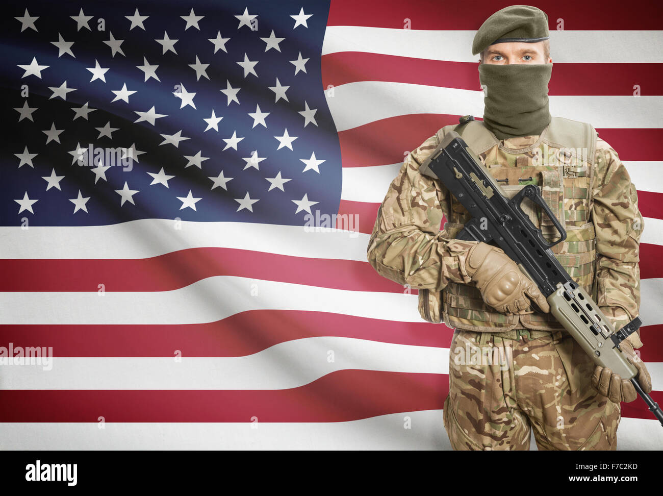 Soldier holding machine gun with national flag on background - United ...