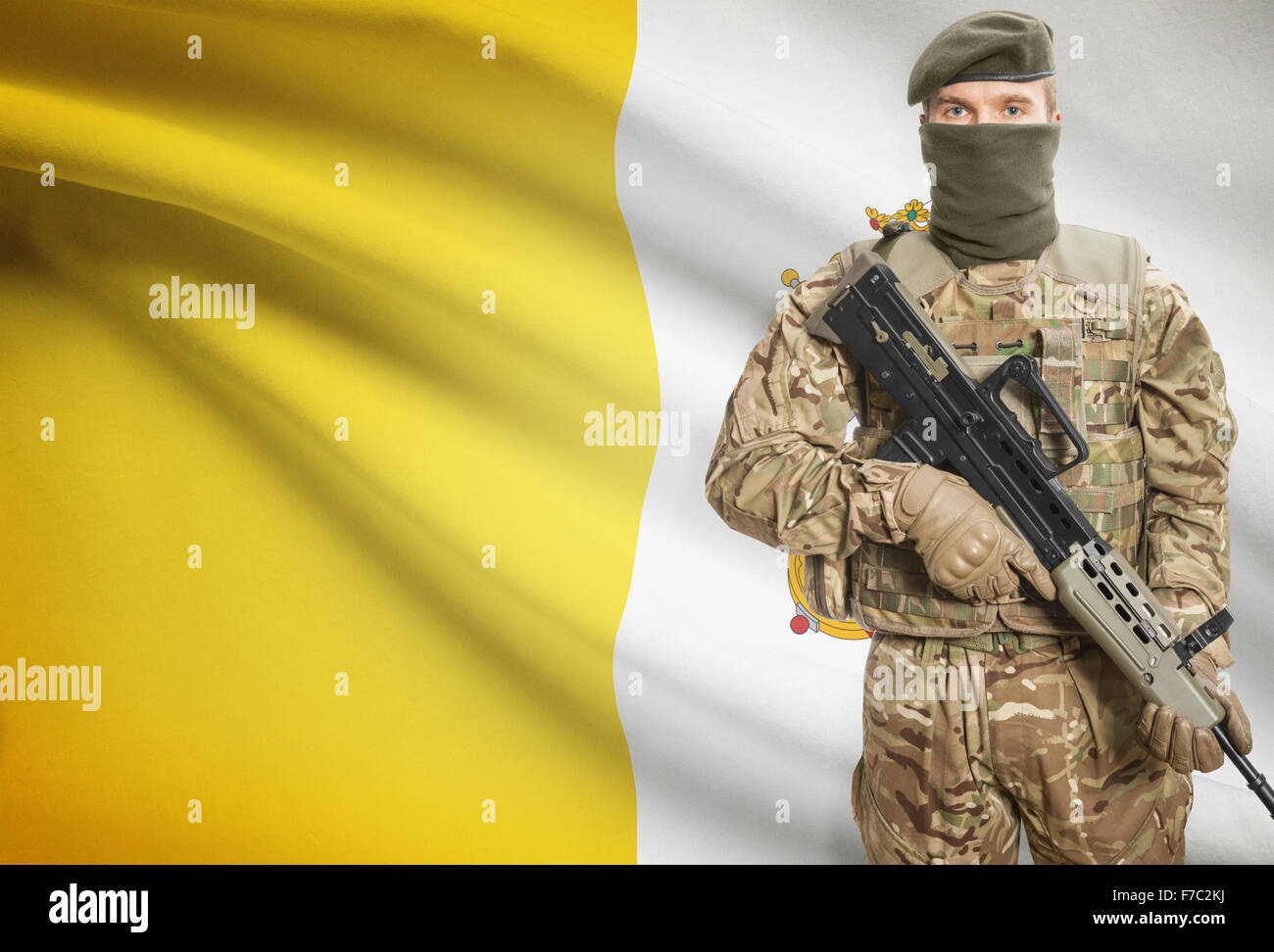 Soldier holding machine gun with national flag on background - Vatican ...