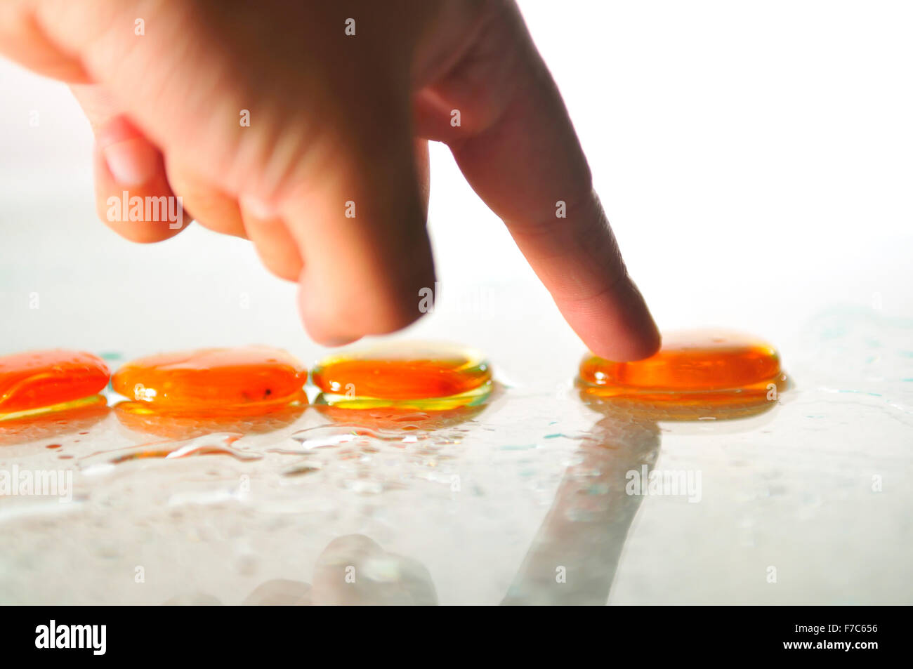Man holding finger on zen stone Stock Photo - Alamy