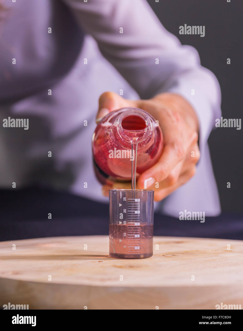 pouring red liquid in beaker on chopping board Stock Photo - Alamy
