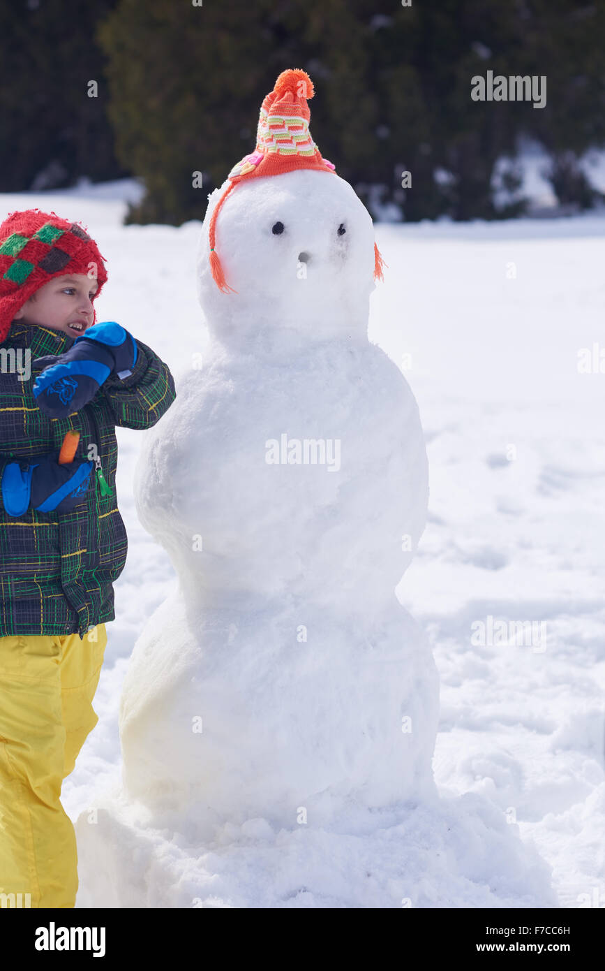 little boy making snowman Stock Photo - Alamy