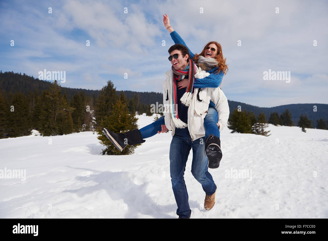 romantic winter scene, happy young couple having fun on fresh show on ...
