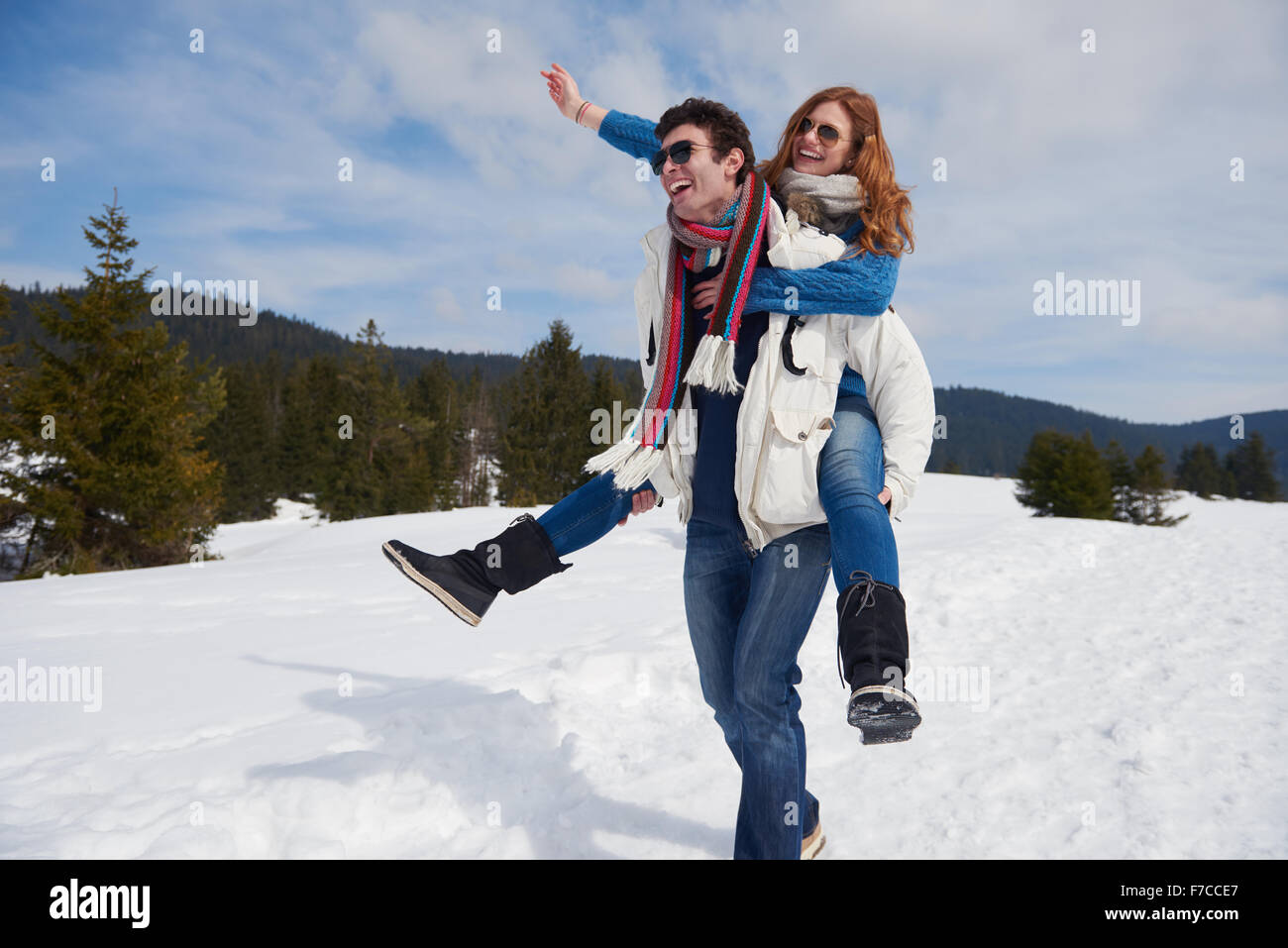 romantic winter scene, happy young couple having fun on fresh show on ...