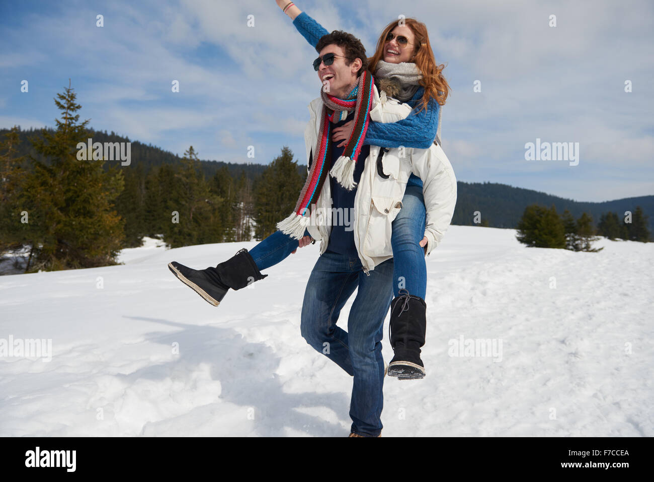 romantic winter scene, happy young couple having fun on fresh show on ...