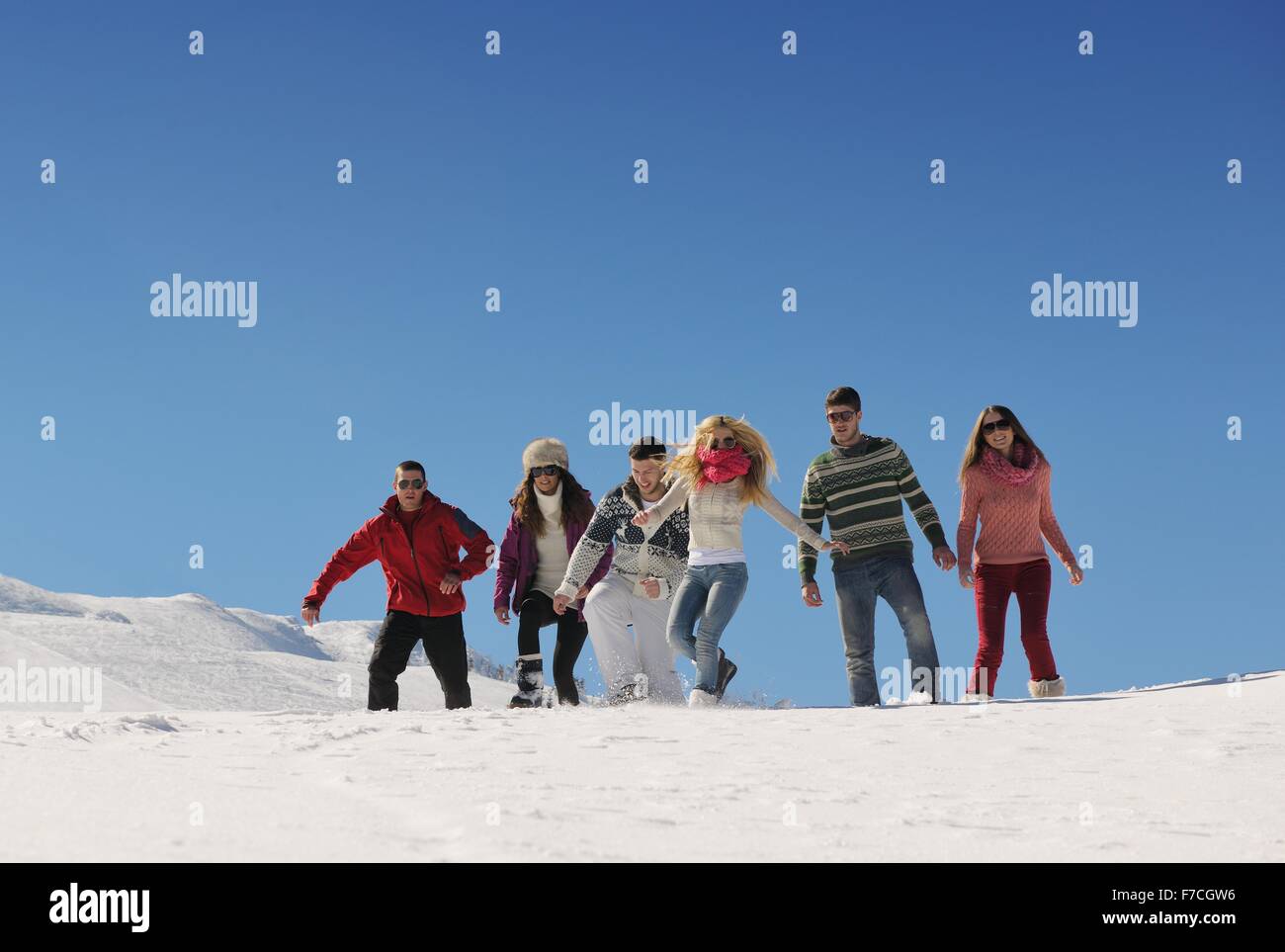 happy friends group have fun at winter on fresh snow, healthy young ...