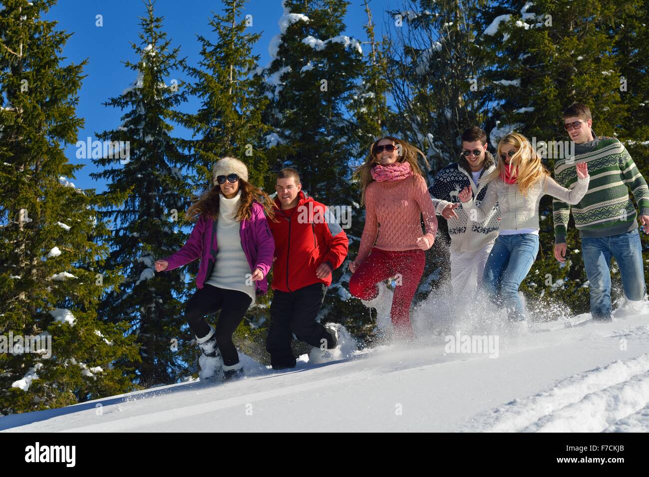happy friends have fun at winter on fresh snow, healthy young people ...