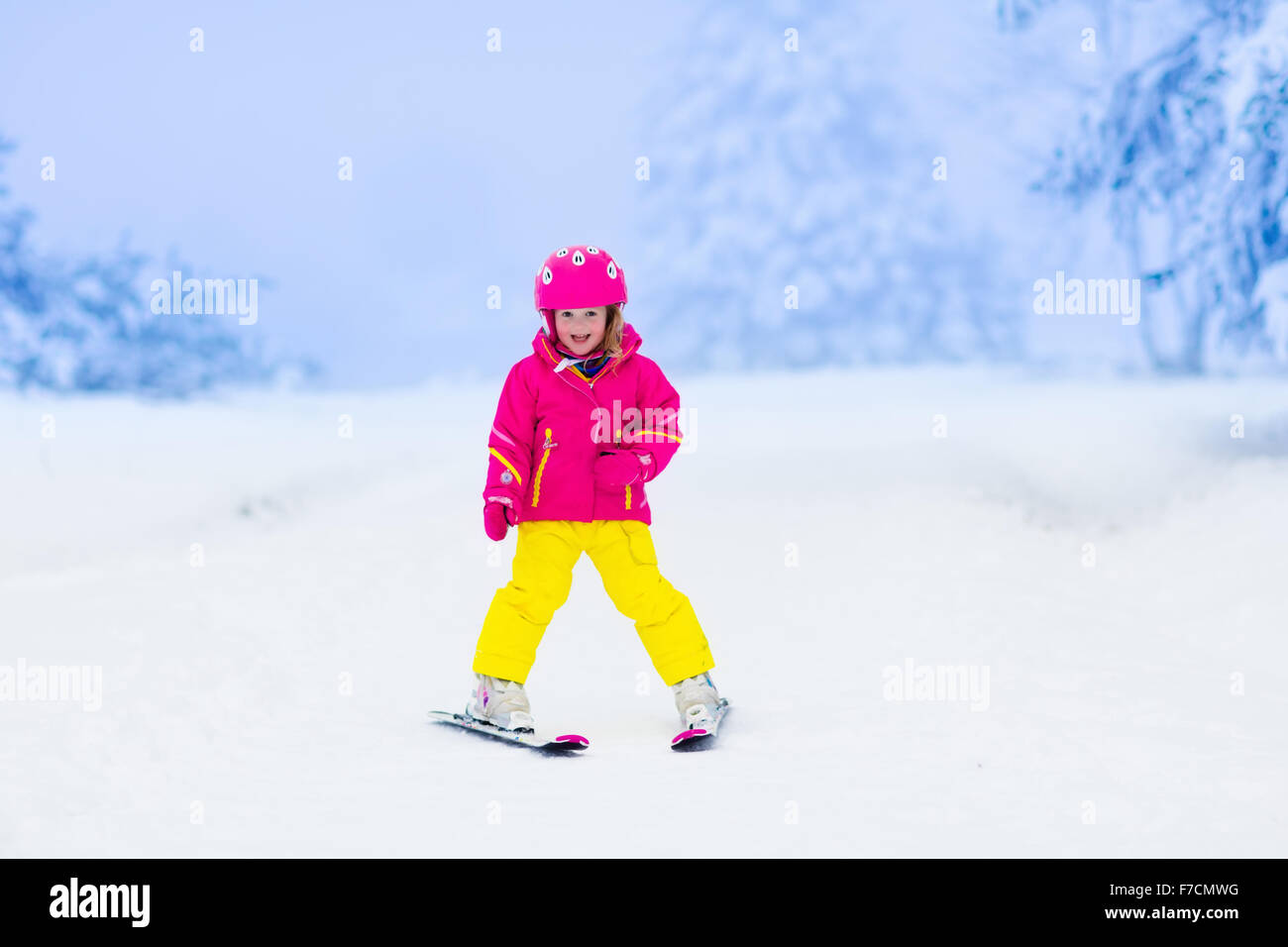 Child skiing in the mountains. Toddler kid in colorful suit and safety ...