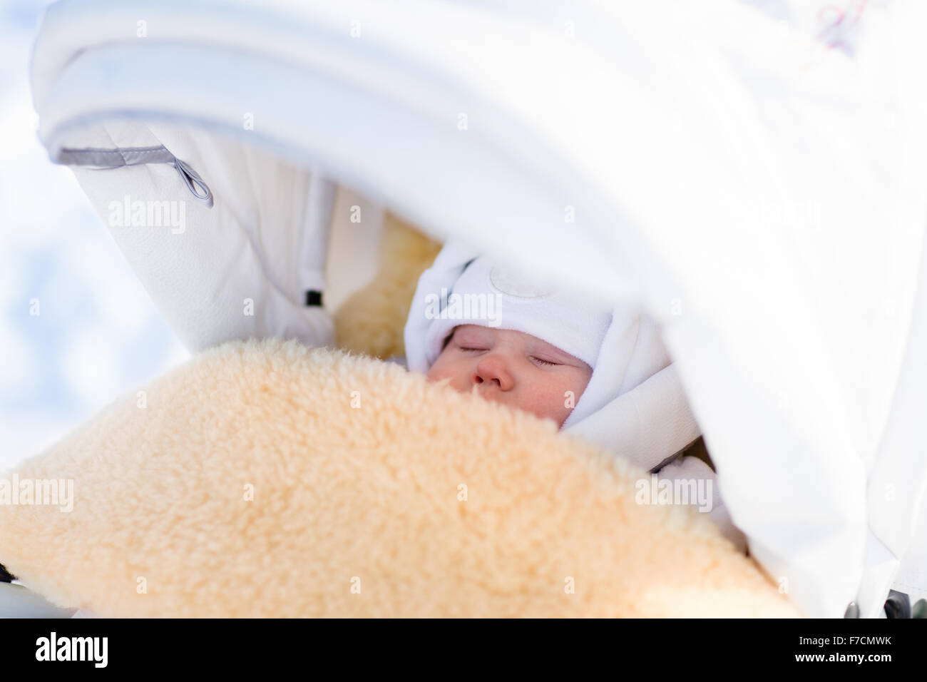 Cute newborn child sleeping in stroller on a cold winter day. New born ...