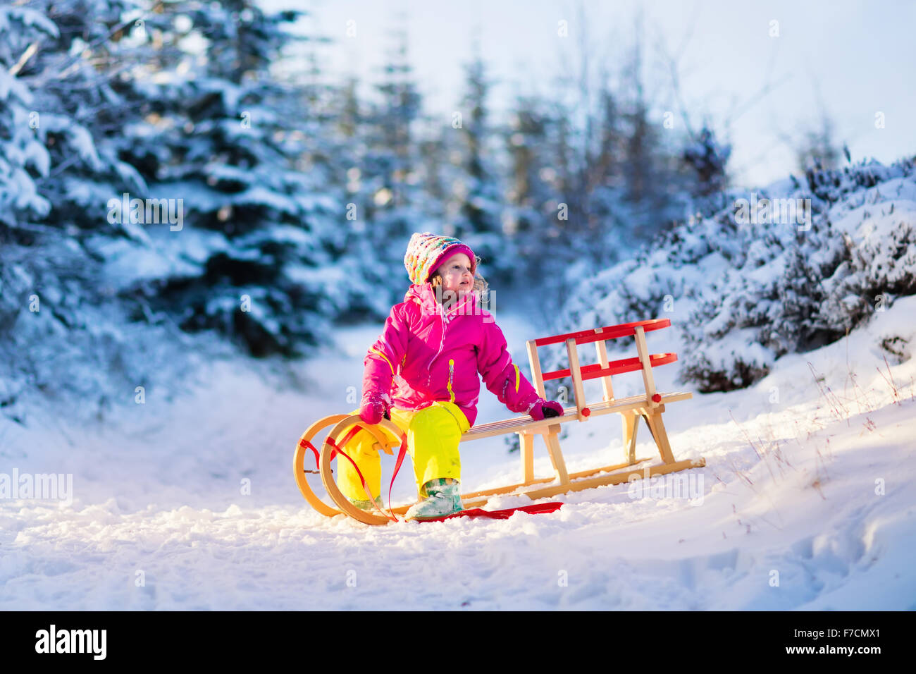 Little girl enjoying sleigh ride. Child sledding. Toddler kid riding a ...